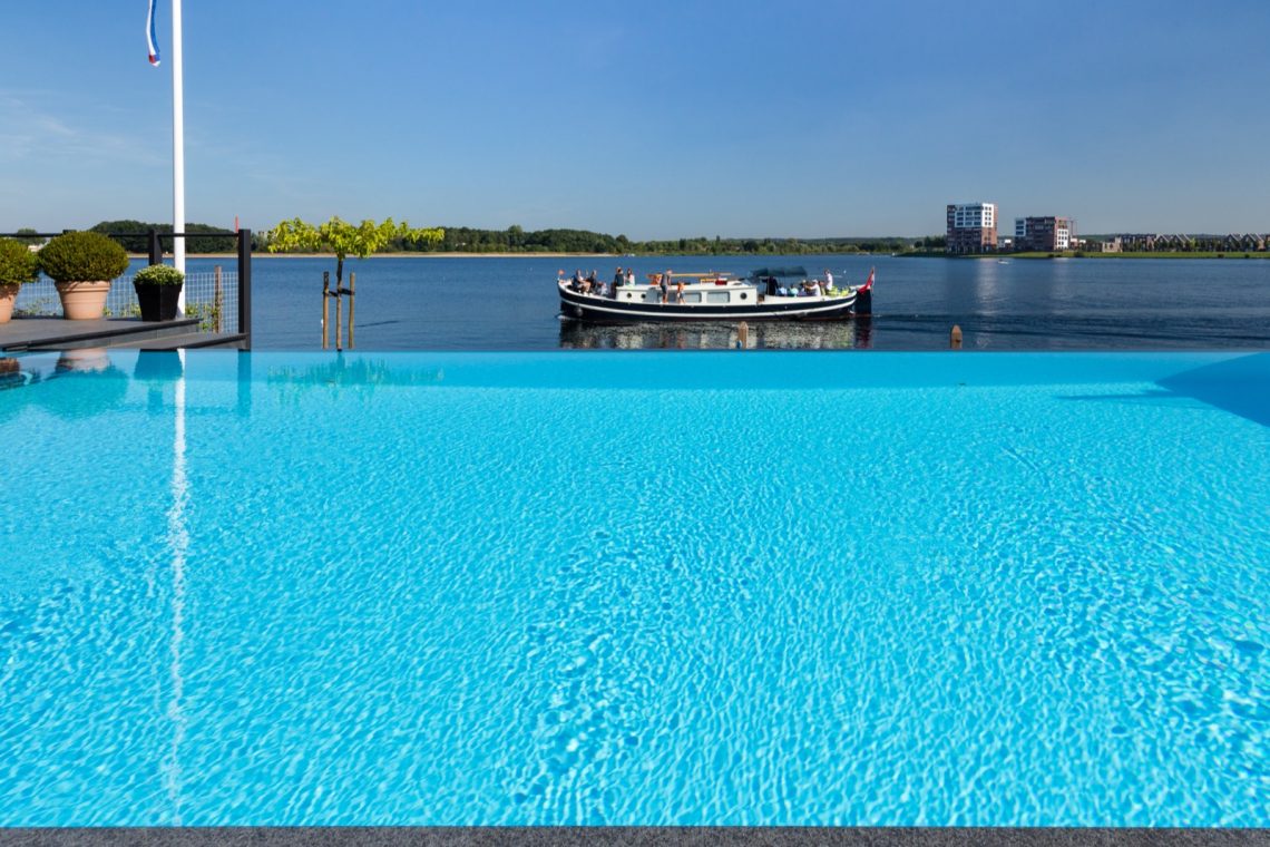 Infinity pool with overflow channel and natural stone bench seating