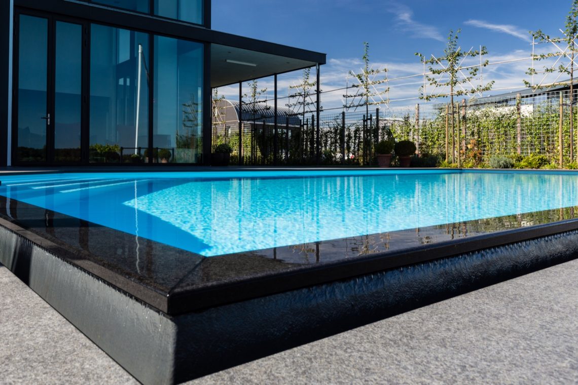 Infinity pool with overflow channel and natural stone bench seating