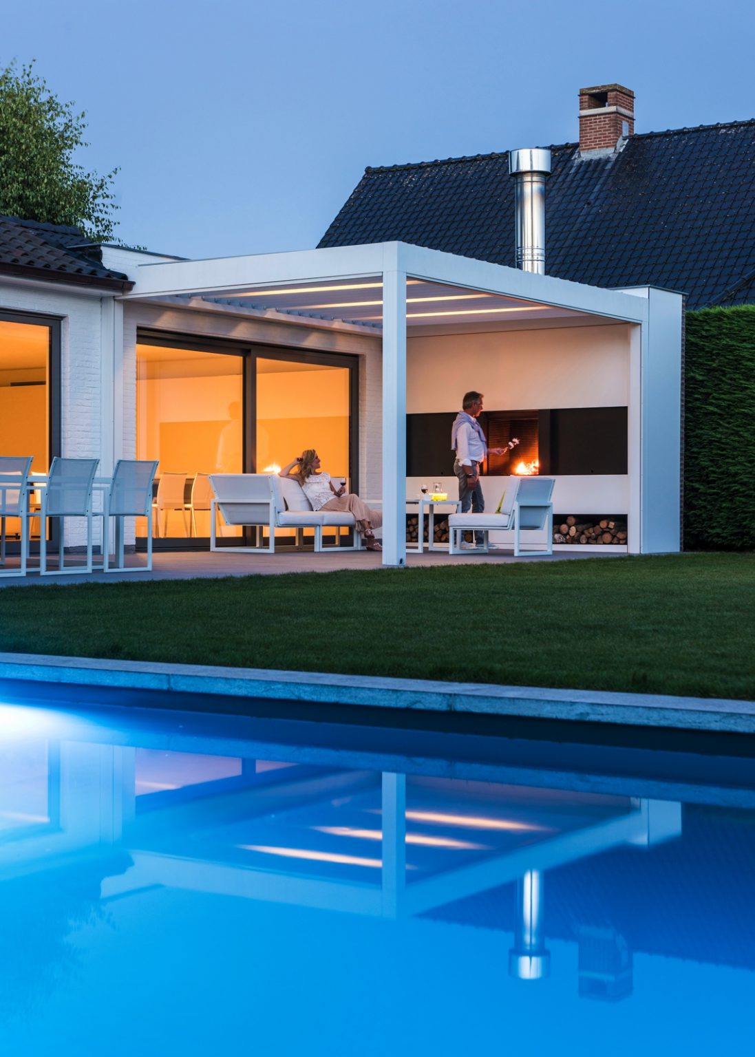 Strakke buitenkamer met lamellendak en open haard