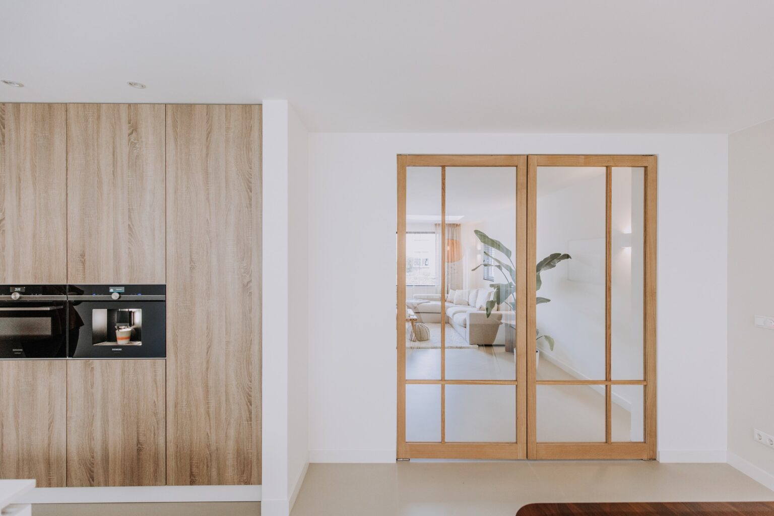 Oak pivot doors in combination with cast floor in Hellendoorn