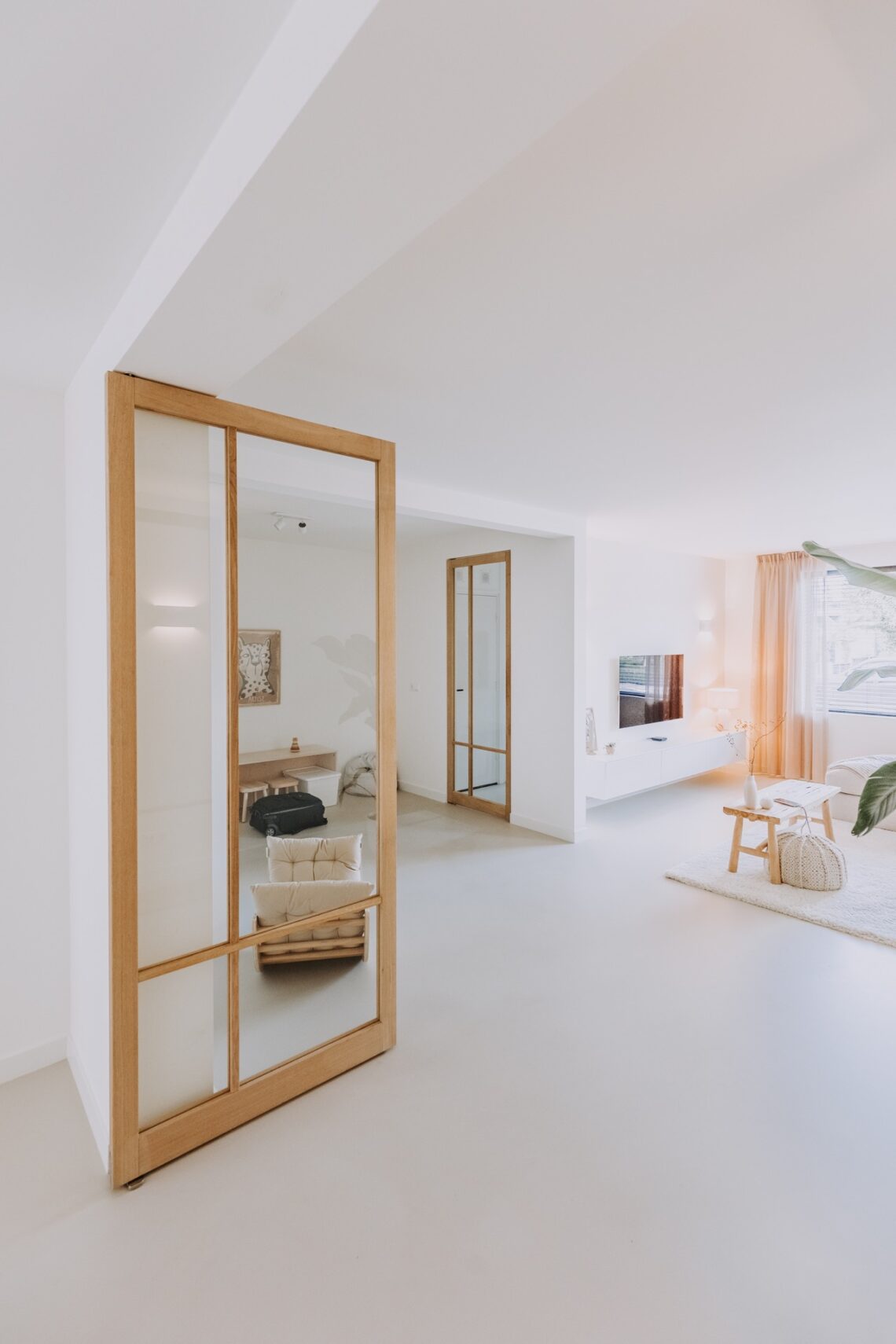 Oak pivot doors in combination with cast floor in Hellendoorn