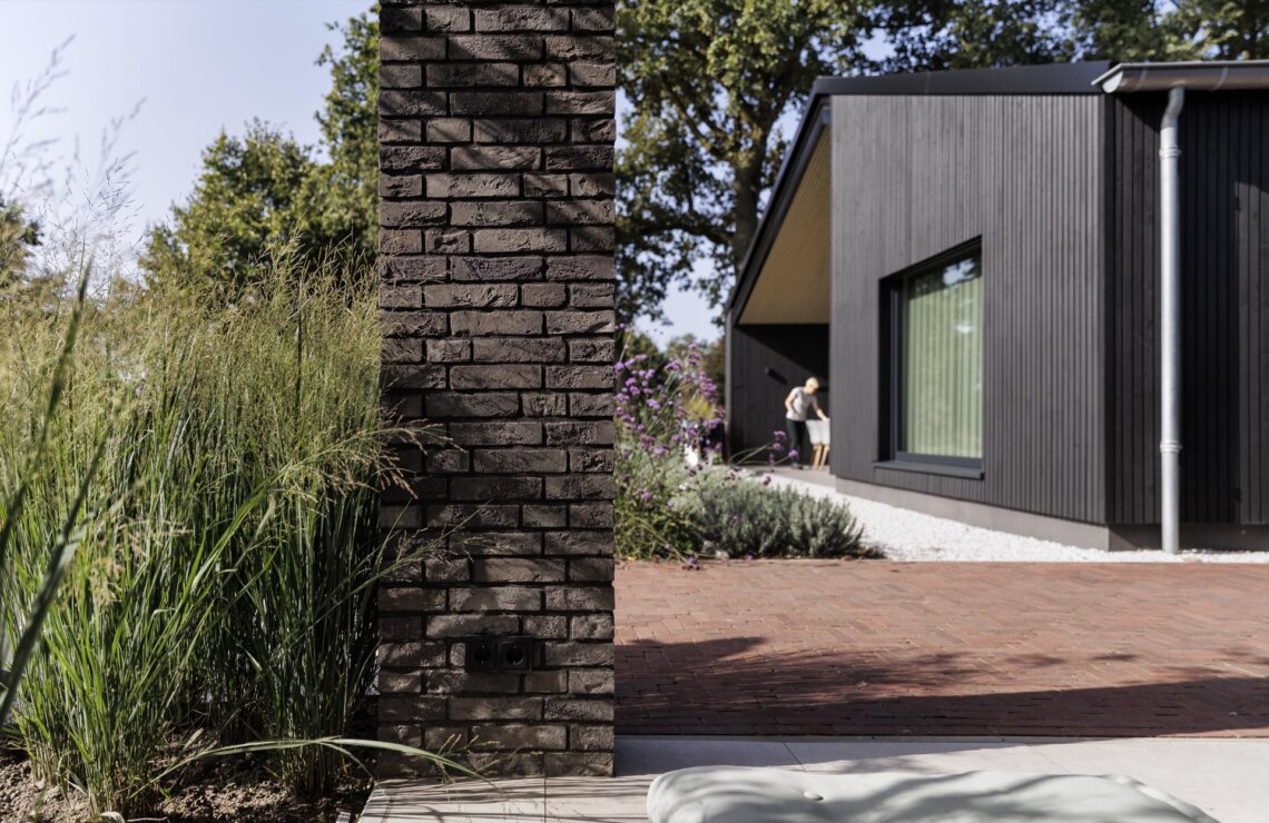 Gesmoorde gevelstenen geven bijgebouw karakter